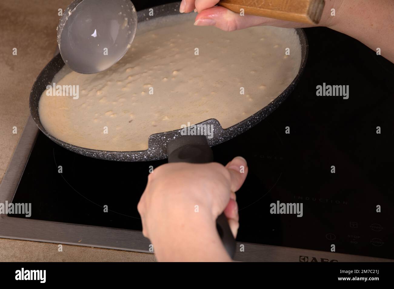 photo preparation of thin pancakes baking in a pan in the kitchen ...