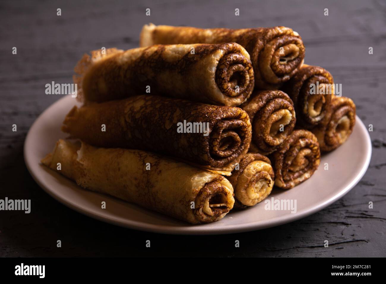 photo of many beautifully stacked fried pancakes on a dark background ...