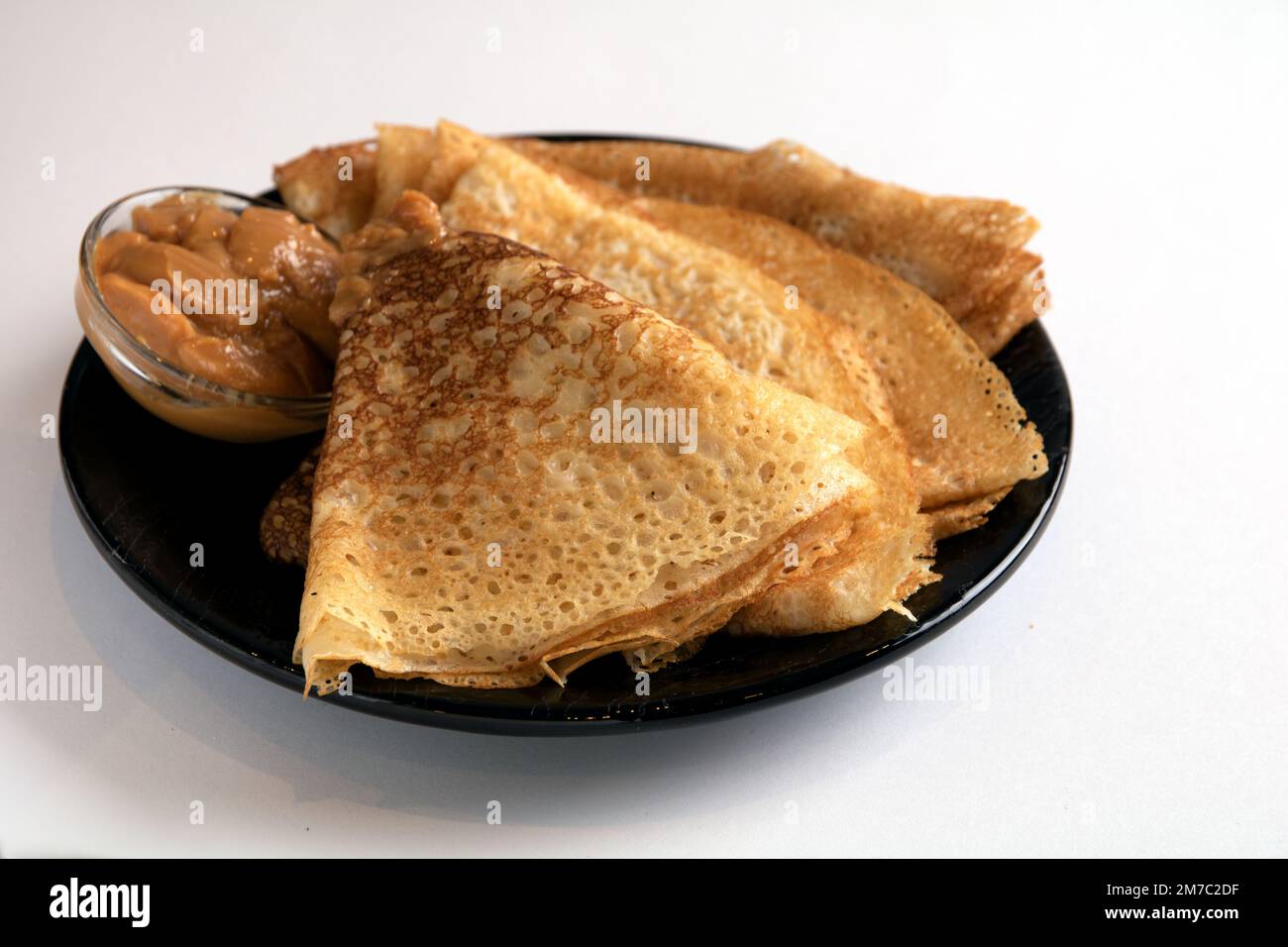 photo fried pancakes with condensed milk on a plate Stock Photo - Alamy