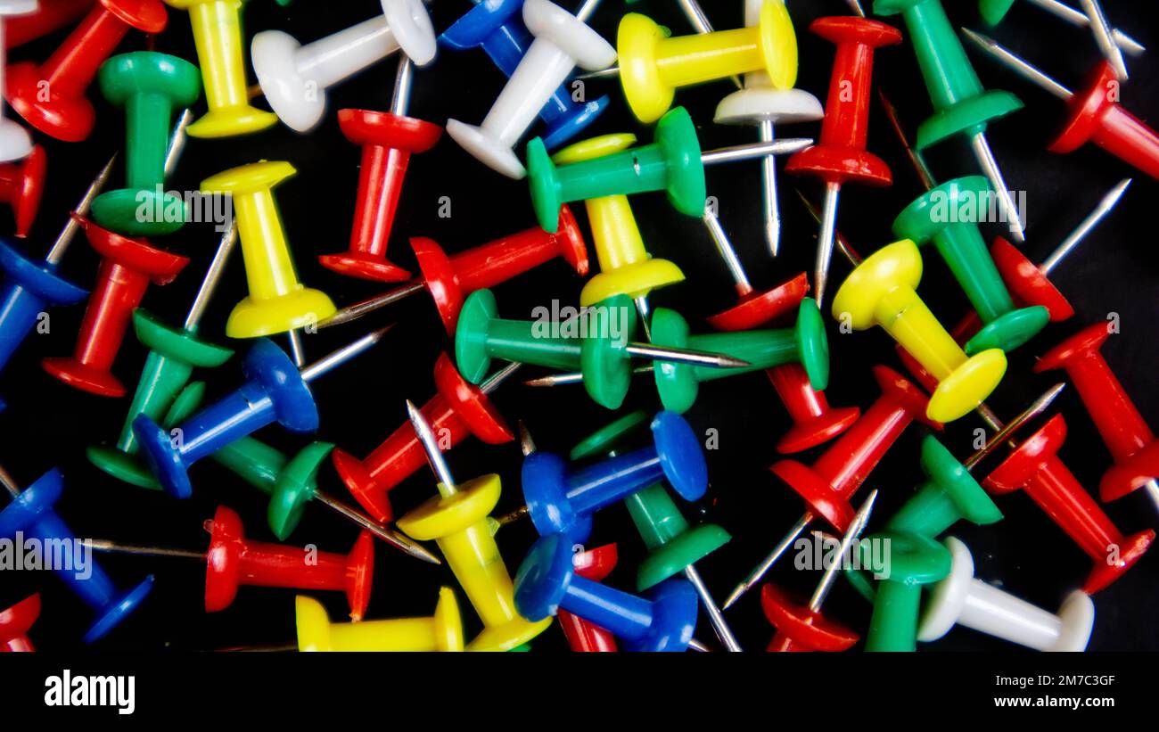 colorful thumbtacks on black background Stock Photo - Alamy