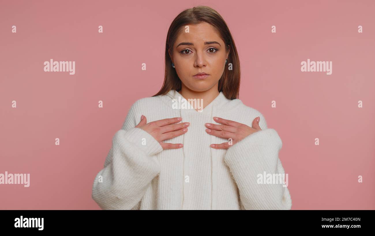 I am not guilty. Confused displeased young woman in white sweater ...