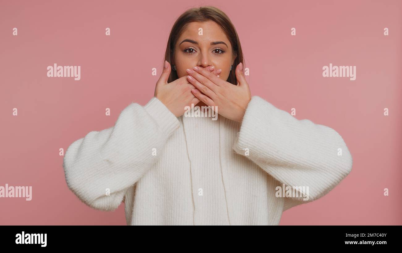 I will not say anyone. Frightened sincere woman closing her mouth with ...