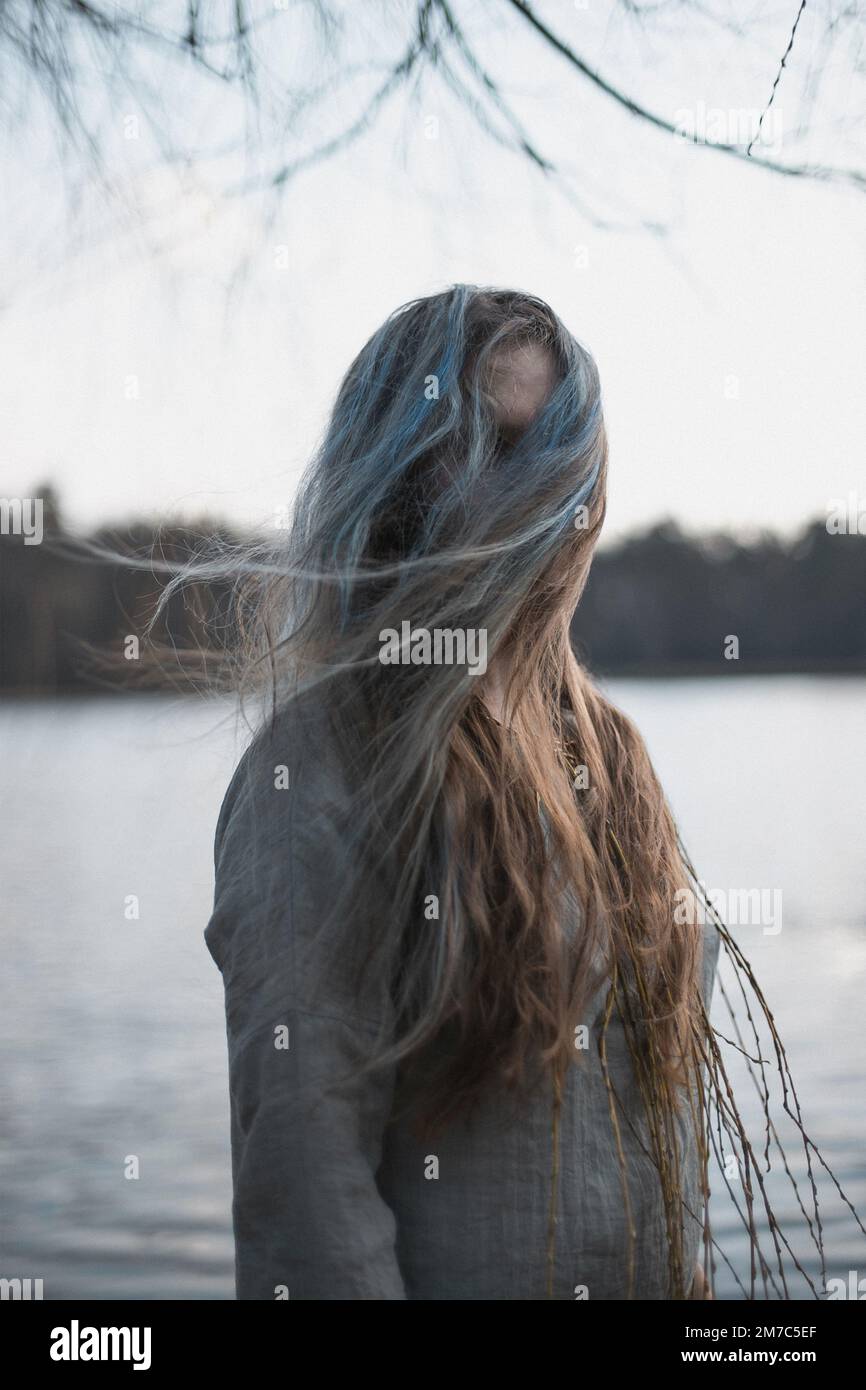 Close up hair flowing in wind and covering adult woman face portrait ...