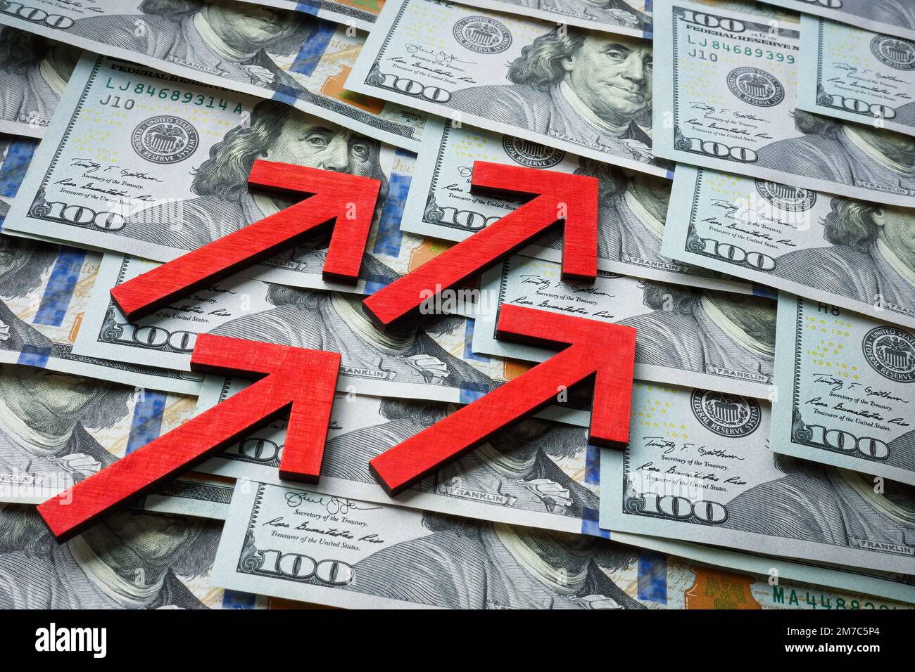 Growing income and savings rising arrows on cash Stock Photo - Alamy