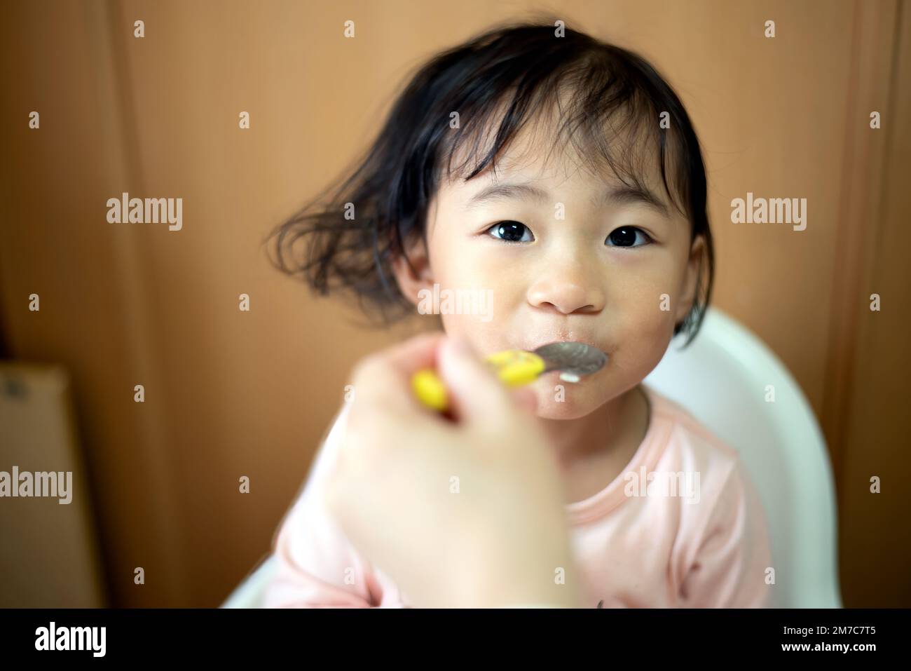 Hand-feeding a toddler with a spoon during a meal Stock Photo - Alamy