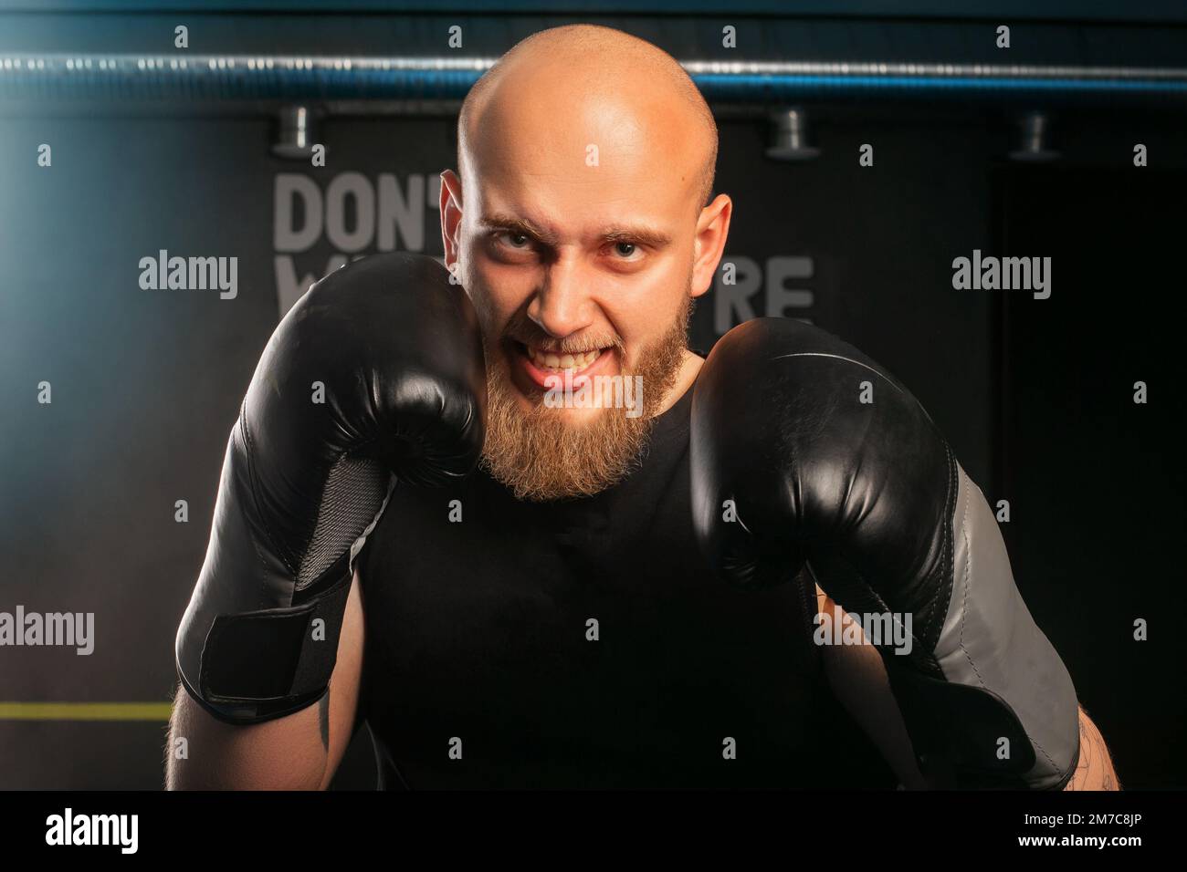 bald men in boxing gloves boxing rack angrily stares into the camera at ...