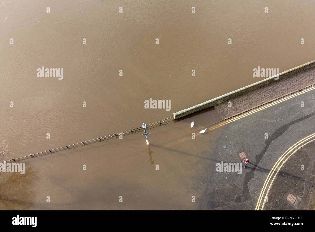 People pass the overflowing river Severn in Worcester following ...