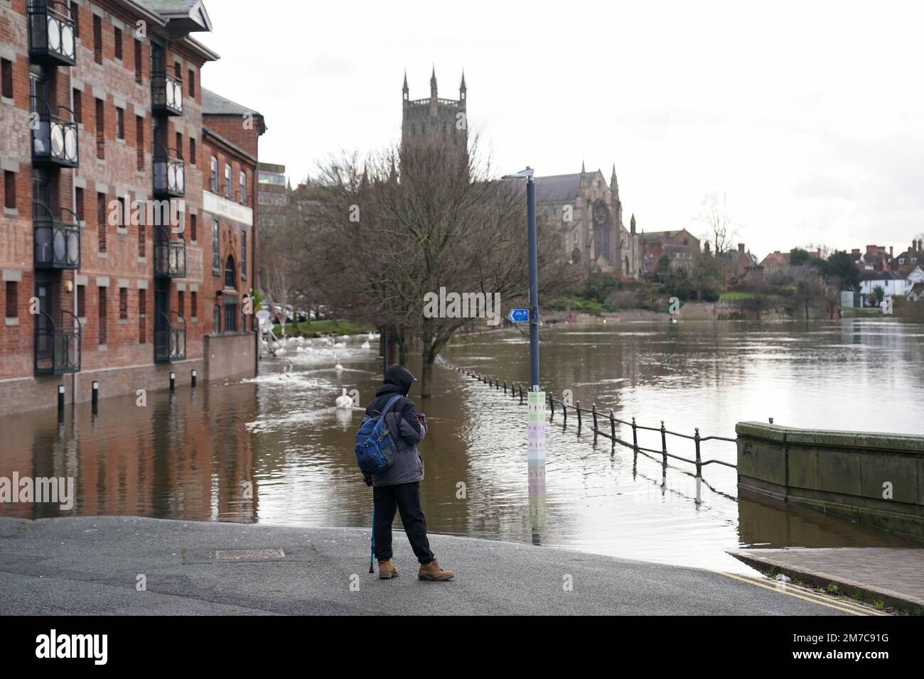 People pass the overflowing river Severn in Worcester following ...