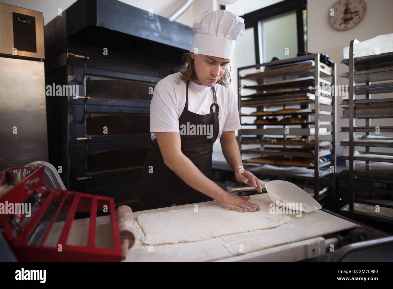 Young baker with chef cap preparing pastries in bakery Stock Photo - Alamy