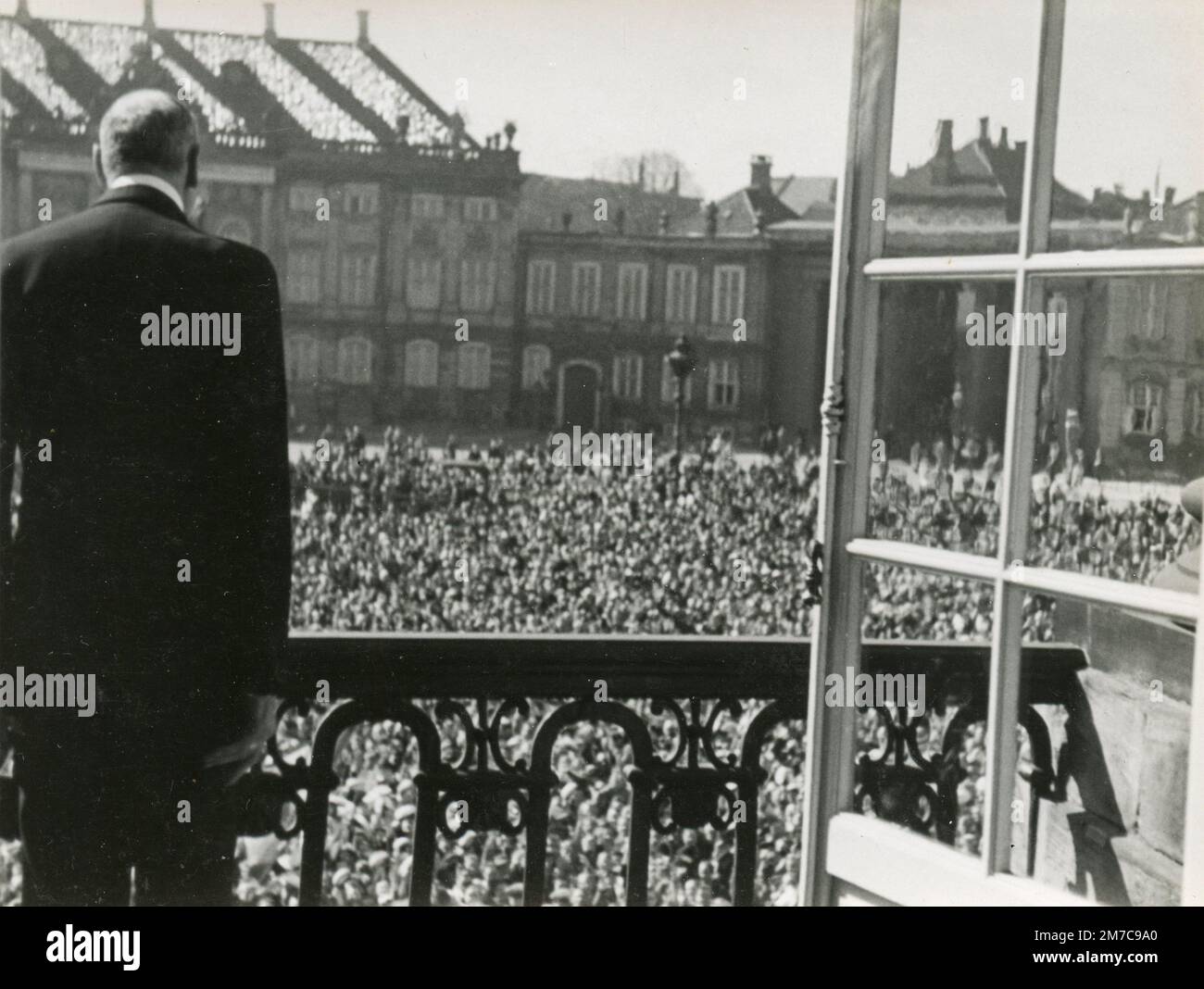 King Christian X of Denmark looks at the crowd from the balcony ...