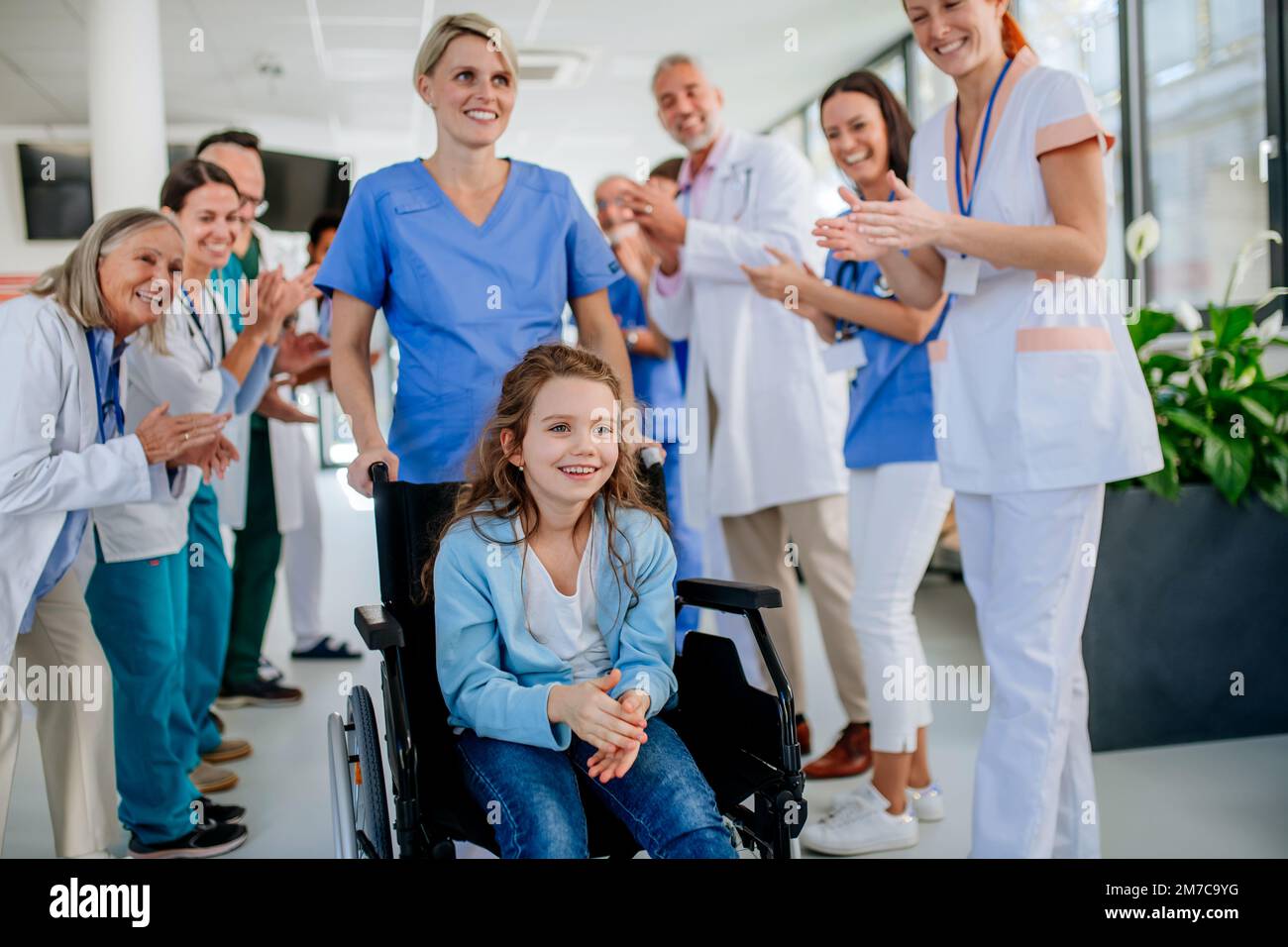 Medical staff clapping to little girl patient who recovered from ...