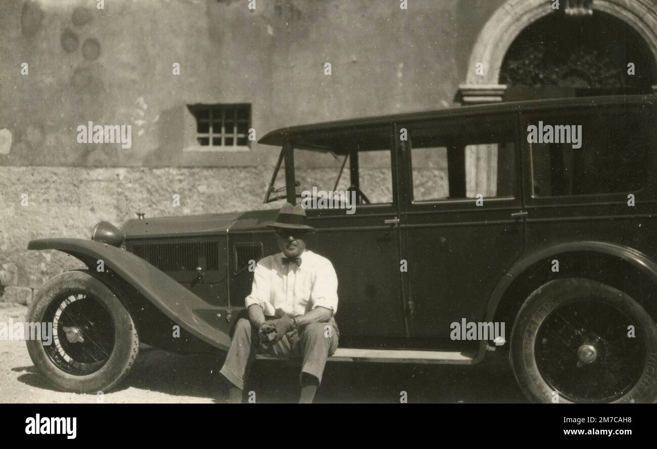 Man sitting on the running board of a Lancia Dilambda car, Italy 1930s ...
