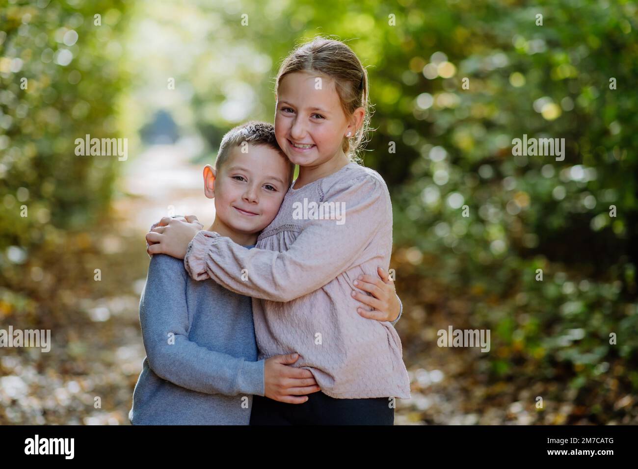 Portrait of little children, siblings, hugging in forest Stock Photo ...