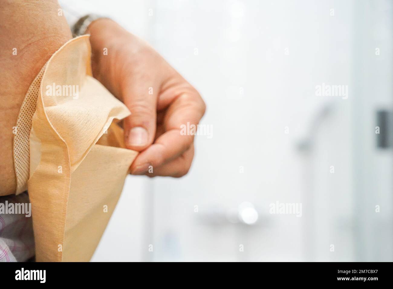 Change of colostomy bag in the bathroom. colon cancer Stock Photo - Alamy