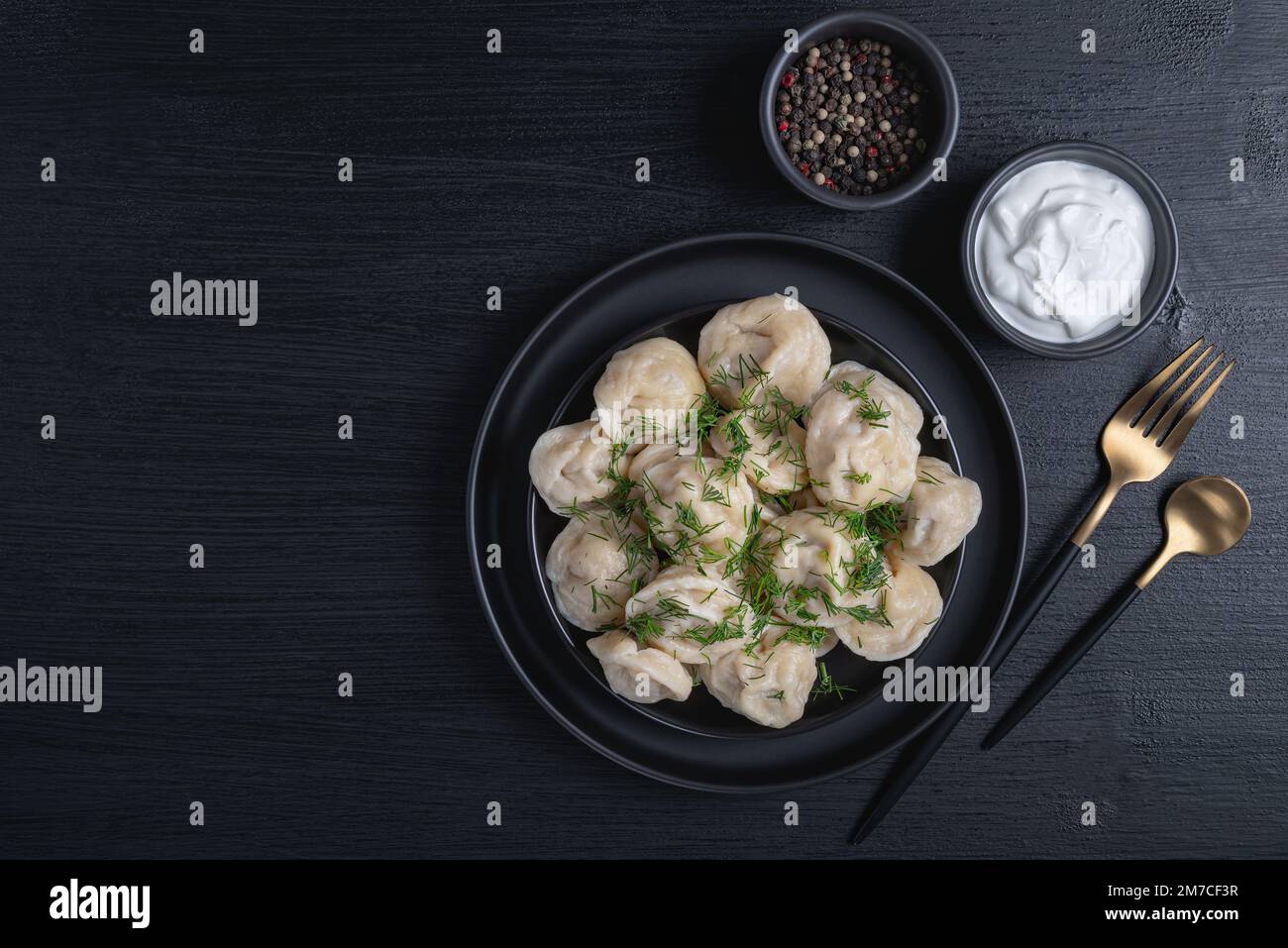 Traditional russian pelmeni, ravioli, dumplings with meat on black ...