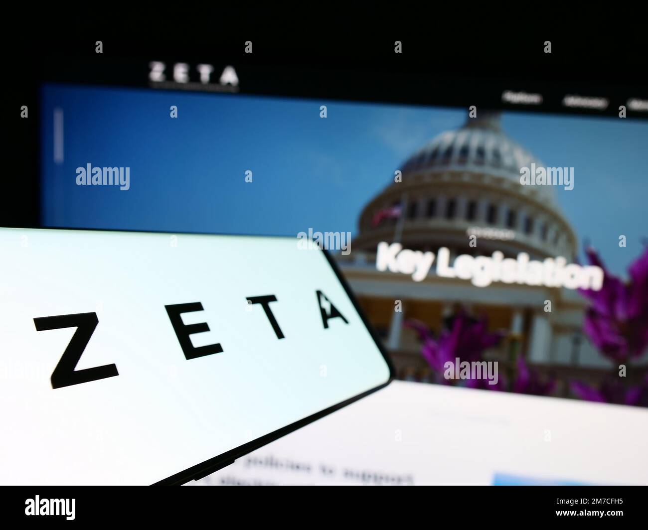 Cellphone with logo of Zero Emission Transportation Association (ZETA) on screen in front of ...