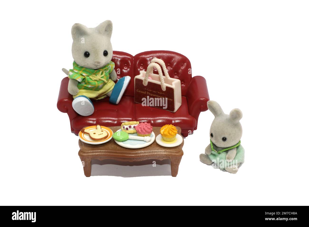 A Sylvanian Families cat and bunny with a handbag sitting on the sofa ...