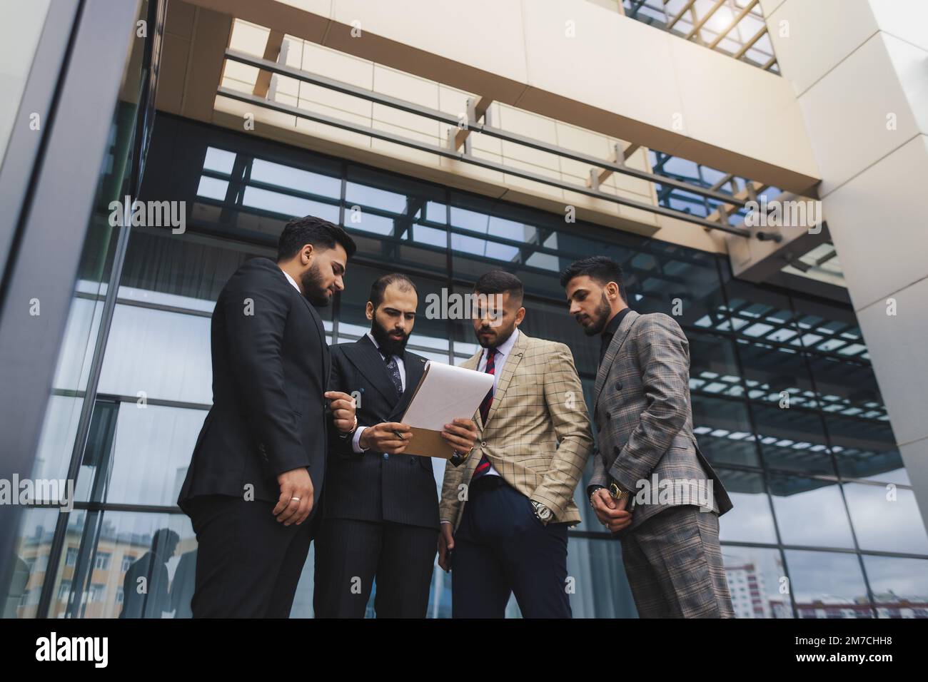 Business people outdoor meeting. Men in jackets discuss working moments ...