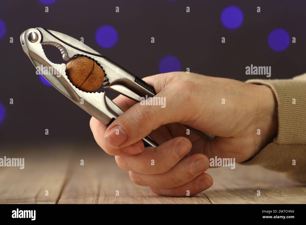 nutcracker in hand over table and colored background Stock Photo - Alamy