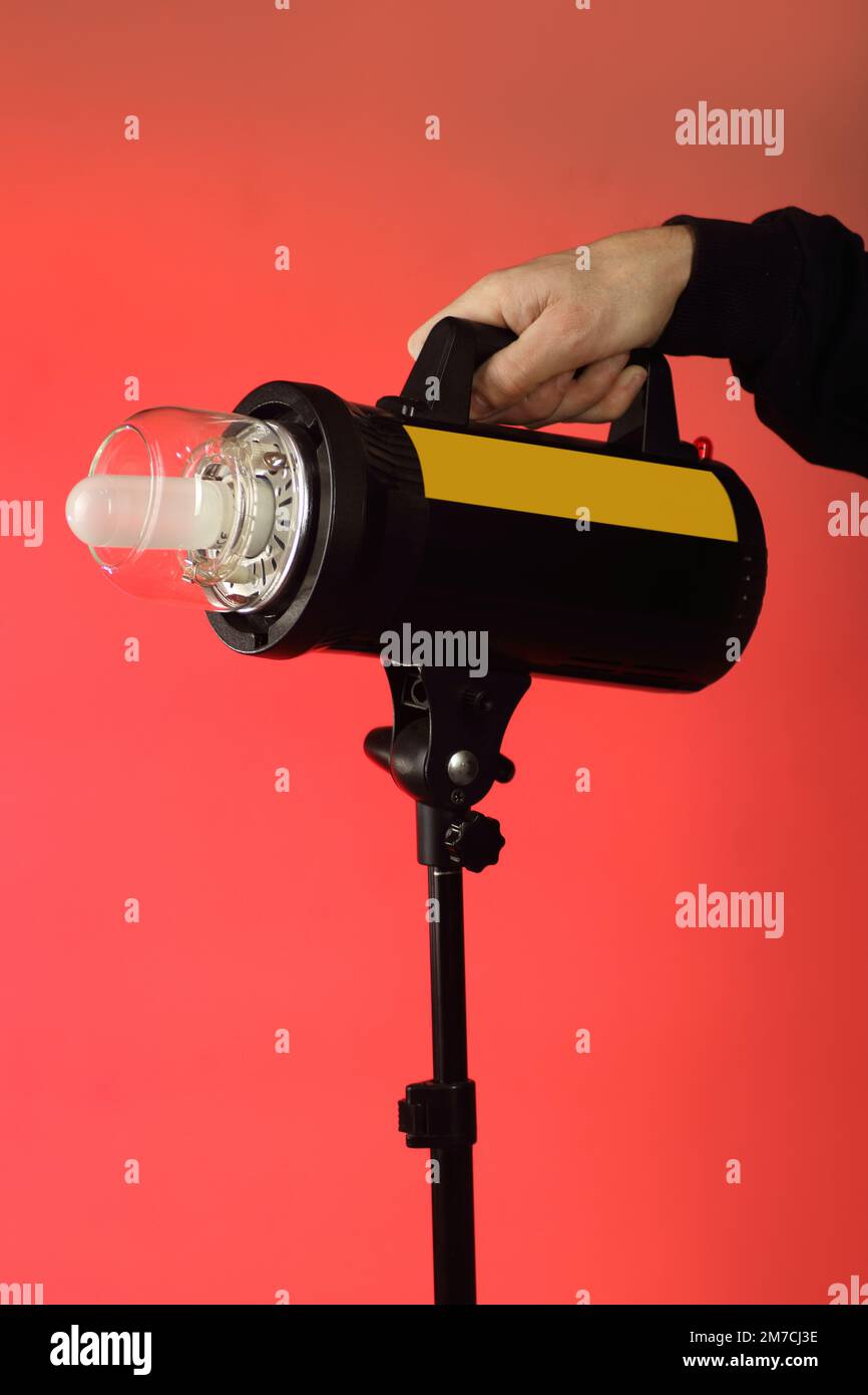 studio flash on a tripod in a person's hand on a pink background Stock ...