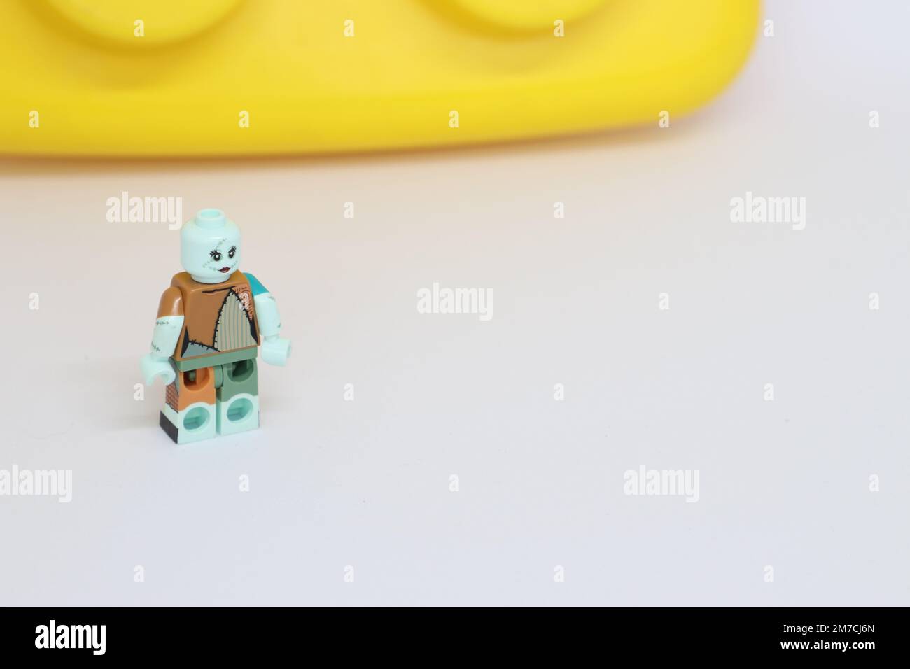 a zombie lego figure with a giant yellow lego block in the background ...
