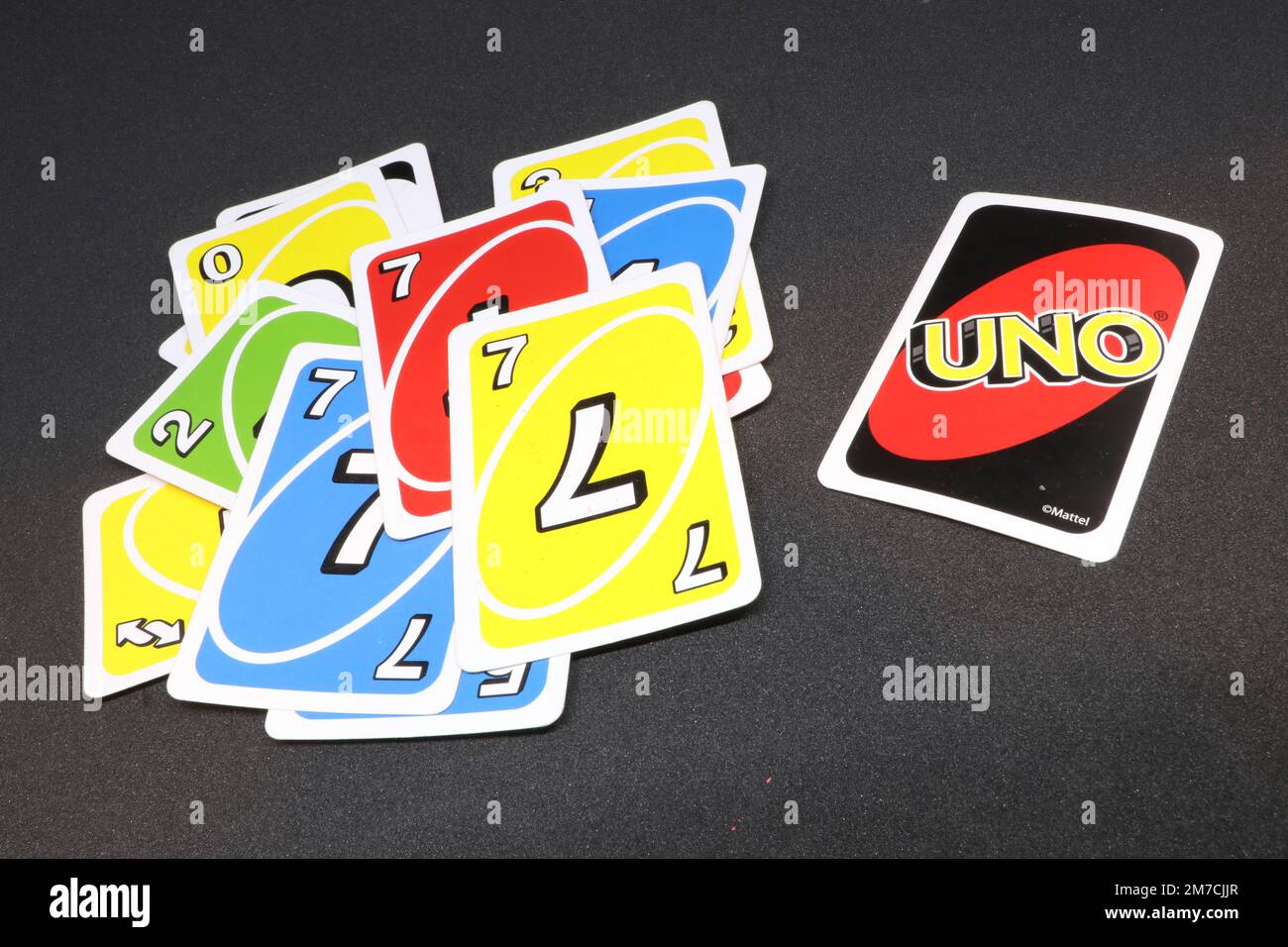A spread of UNO cards isolated on a black background displaying red ...