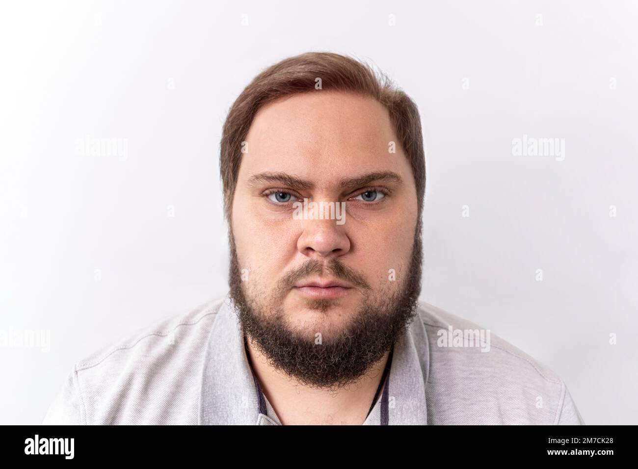 a serious man with a beard on a white background in a shirt Stock Photo ...