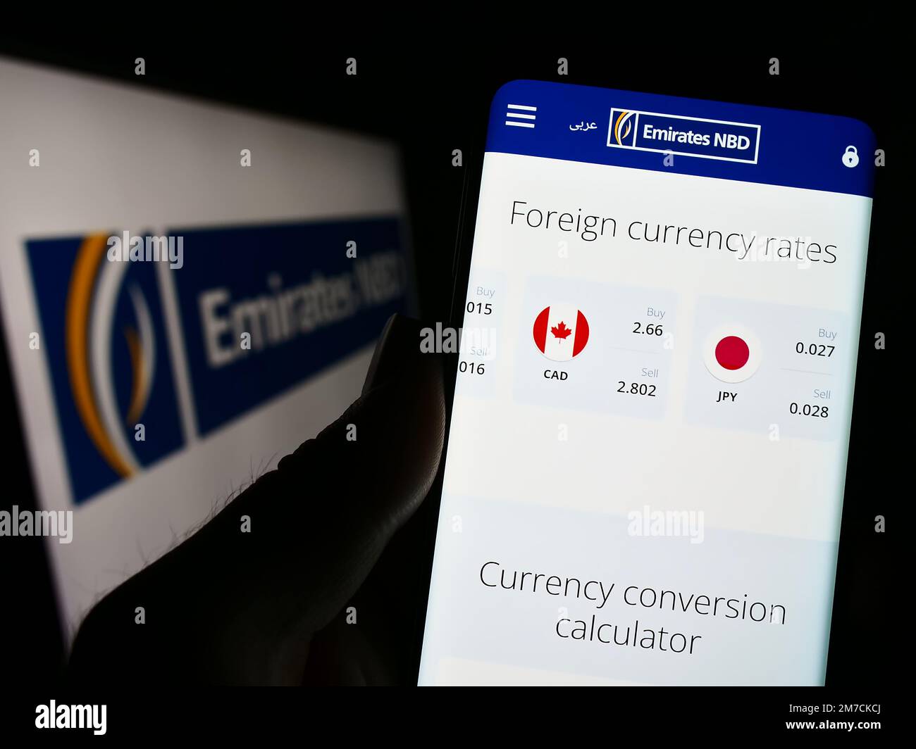 Person holding cellphone with webpage of financial company Emirates NBD ...