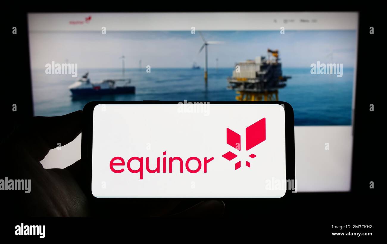 Person holding cellphone with logo of Norwegian energy company Equinor ...