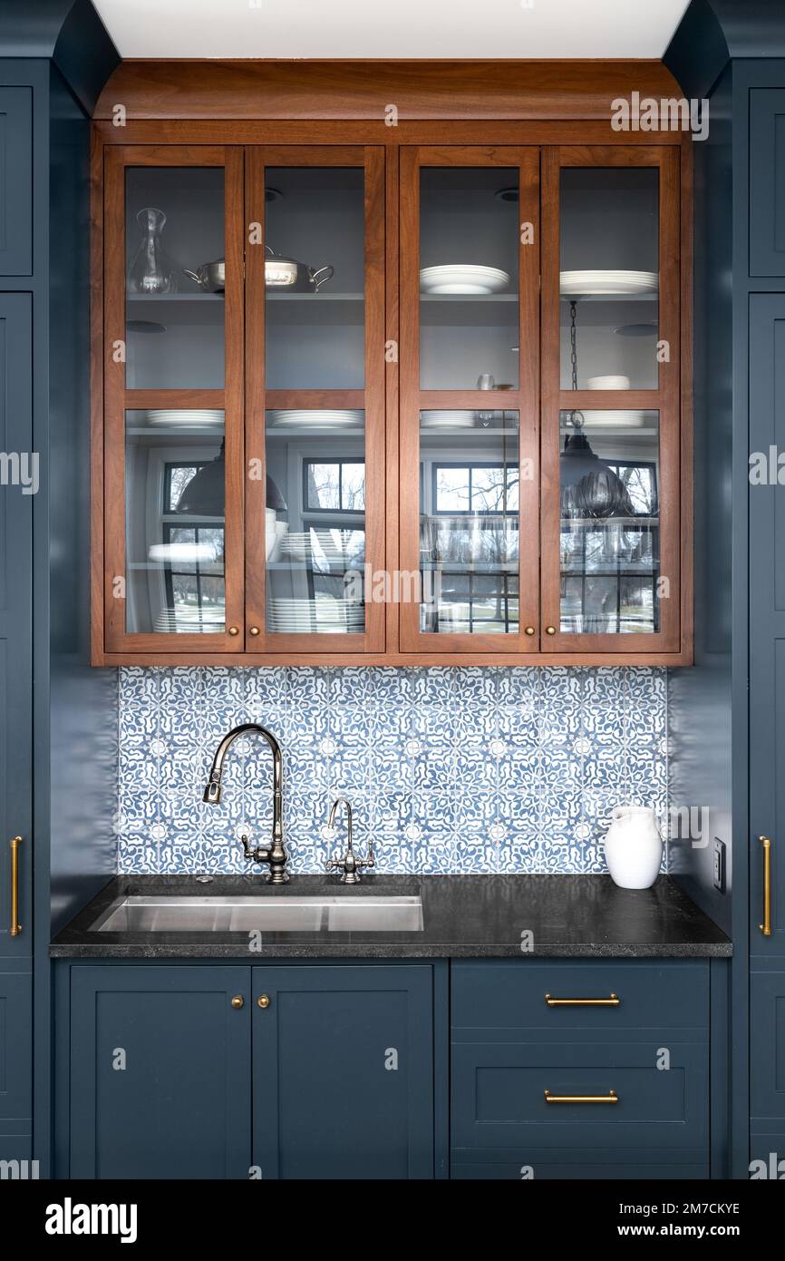 A kitchen sink with a beautiful pattern tiled backsplash with a chrome ...