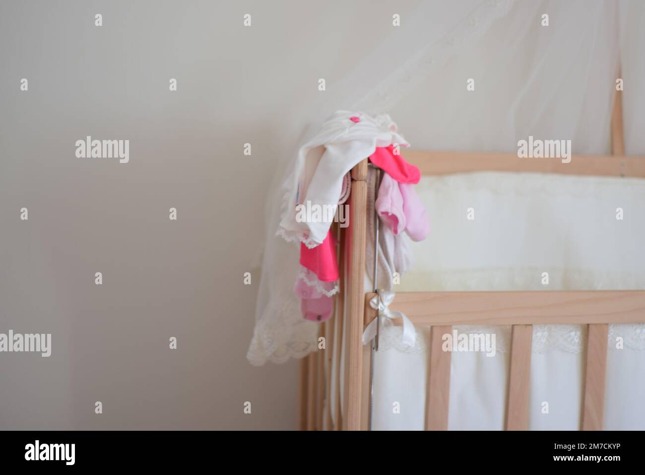 Wooden baby cradle and baby clothes Stock Photo - Alamy
