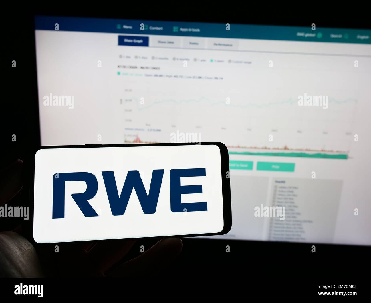 Person holding mobile phone with logo of German energy company RWE AG ...