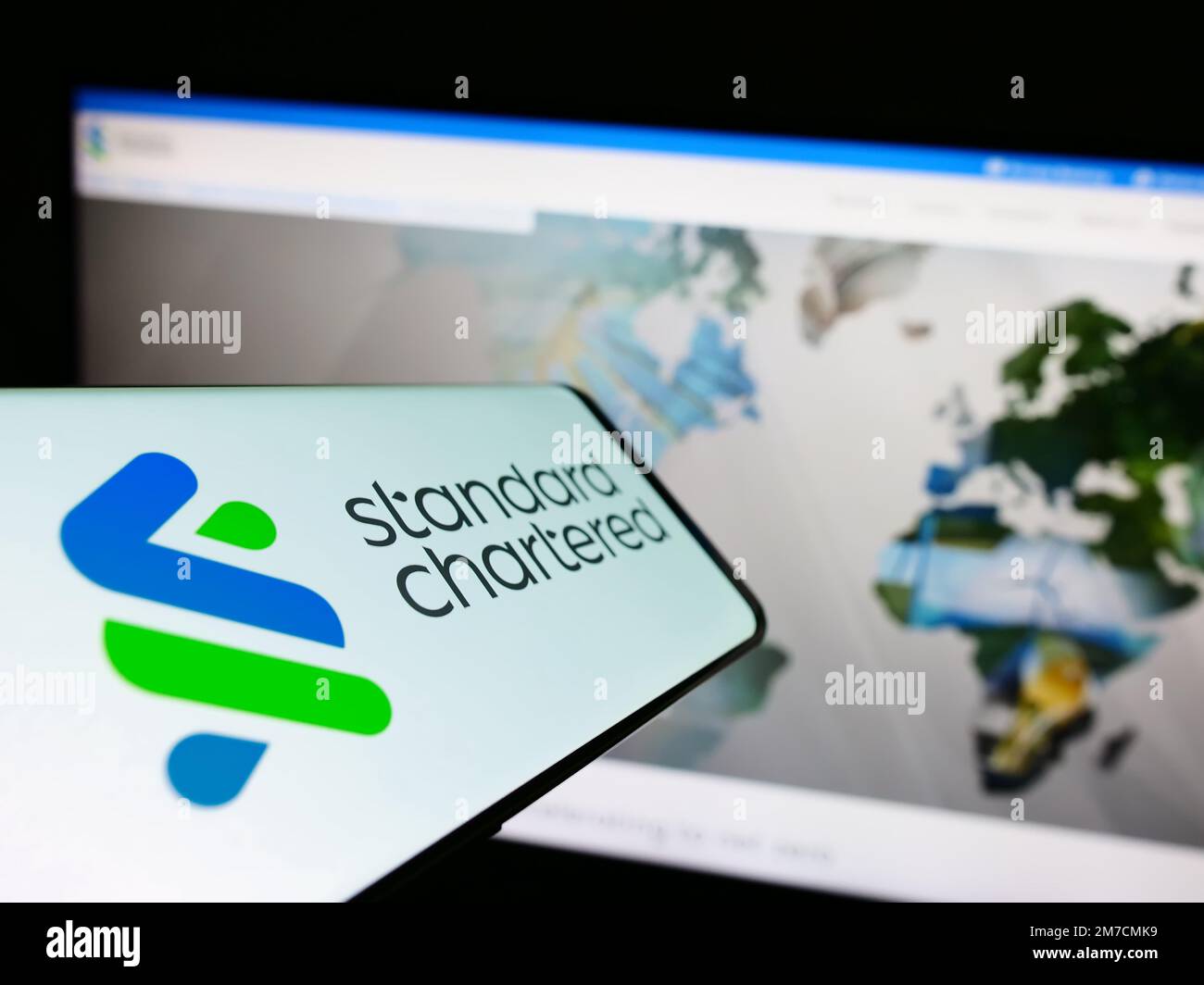 Mobile phone with logo of financial company Standard Chartered plc on ...