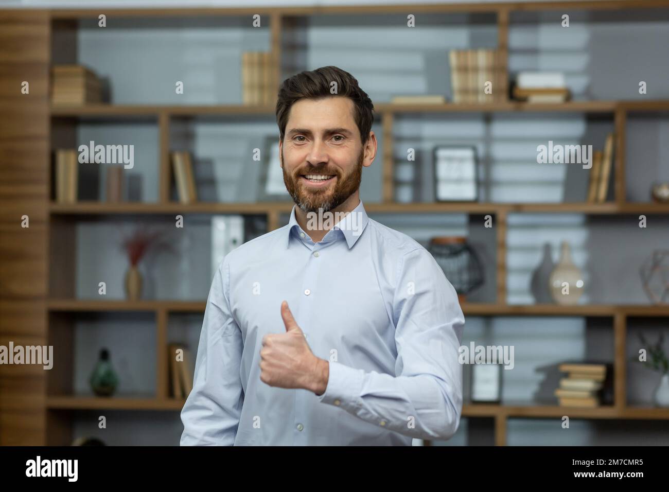 Successful businessman smiling and looking at camera, man shows thumbs ...