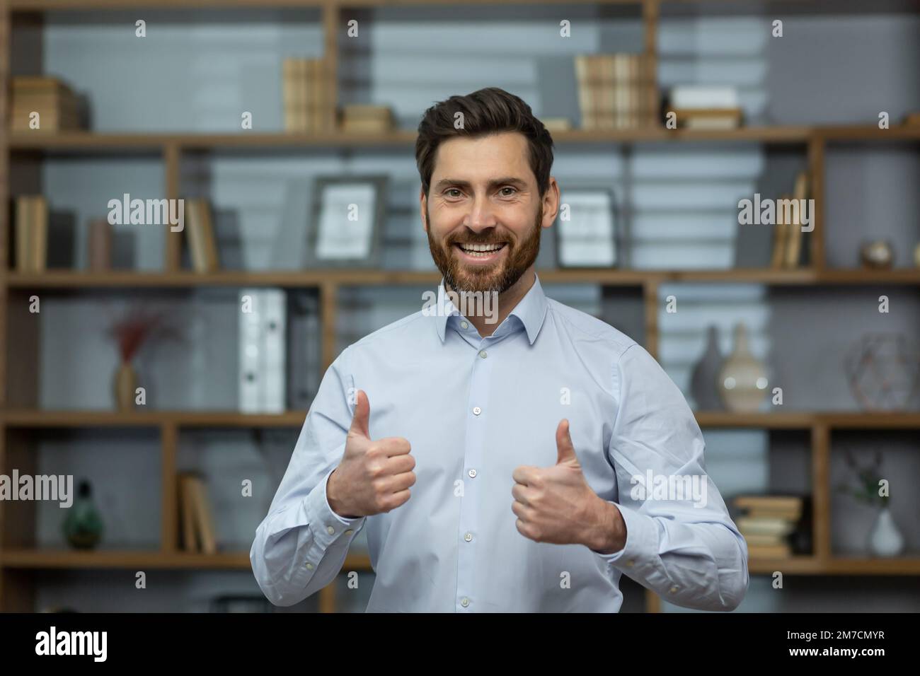 Successful businessman smiling and looking at camera, man shows thumbs ...