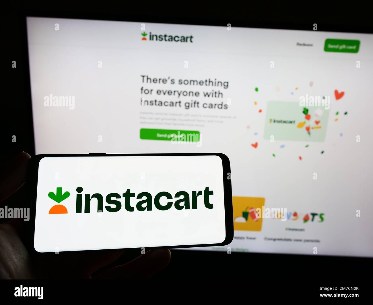 Person holding smartphone with logo of US retail company Maplebear Inc ...