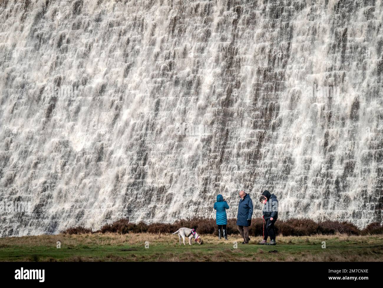 People look on as water pours down the front of Derwent Dam in ...