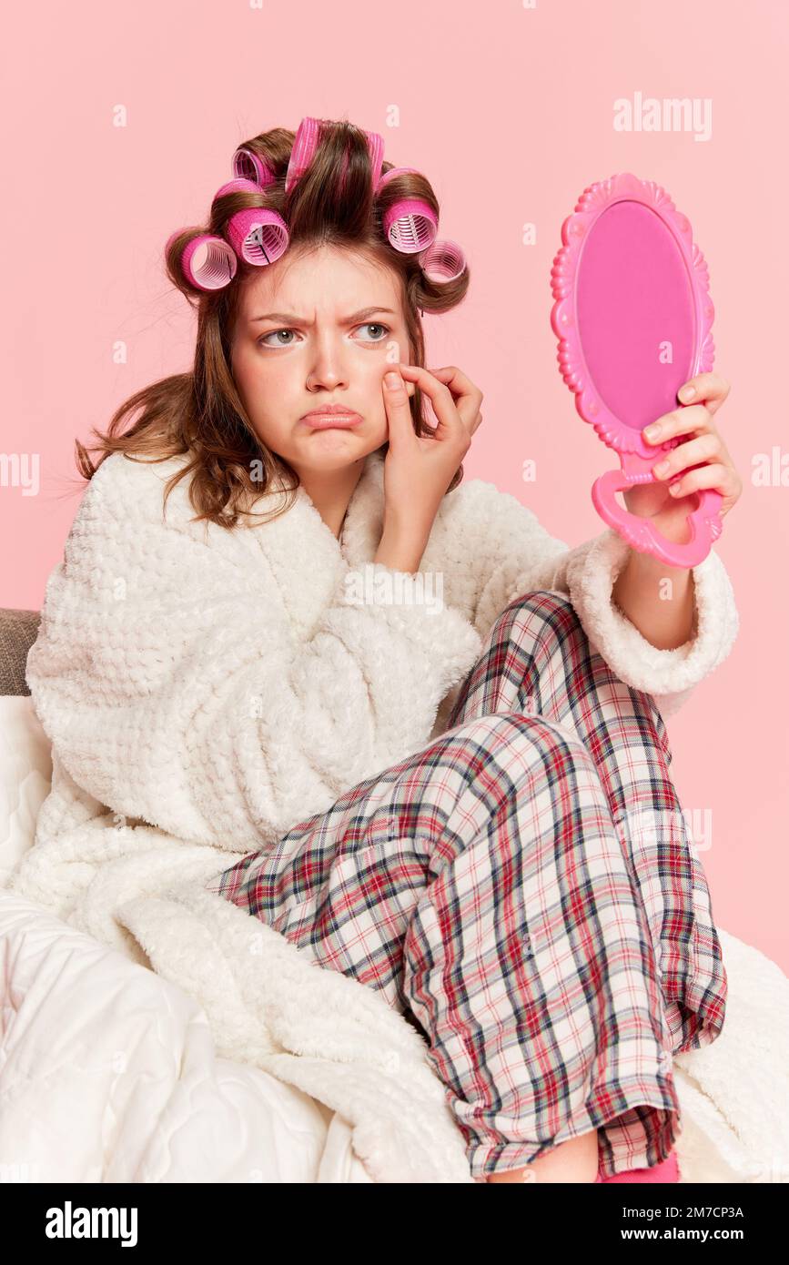 Studio shot of smiling happy young woman in homewear with rollers in ...