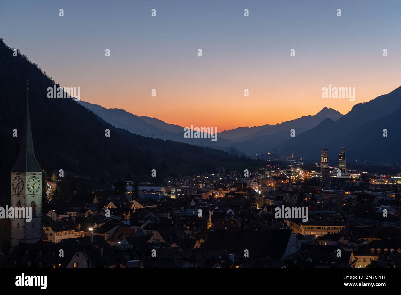 A beautiful view of a town at dusk with mountains in the background ...