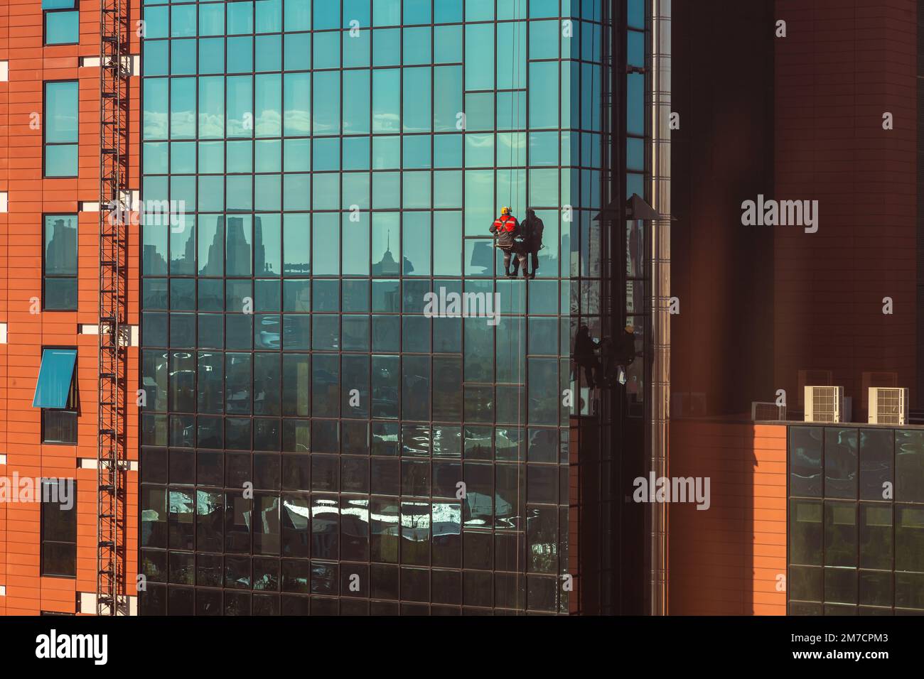 High-rise workers cleaning the windows of a skyscraper Stock Photo - Alamy