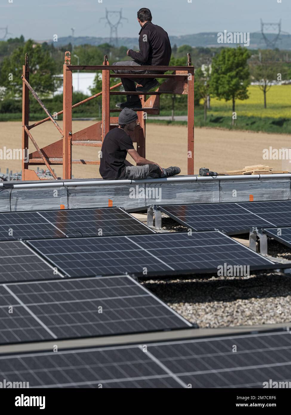 Male team engineers installing stand-alone solar photovoltaic panel ...