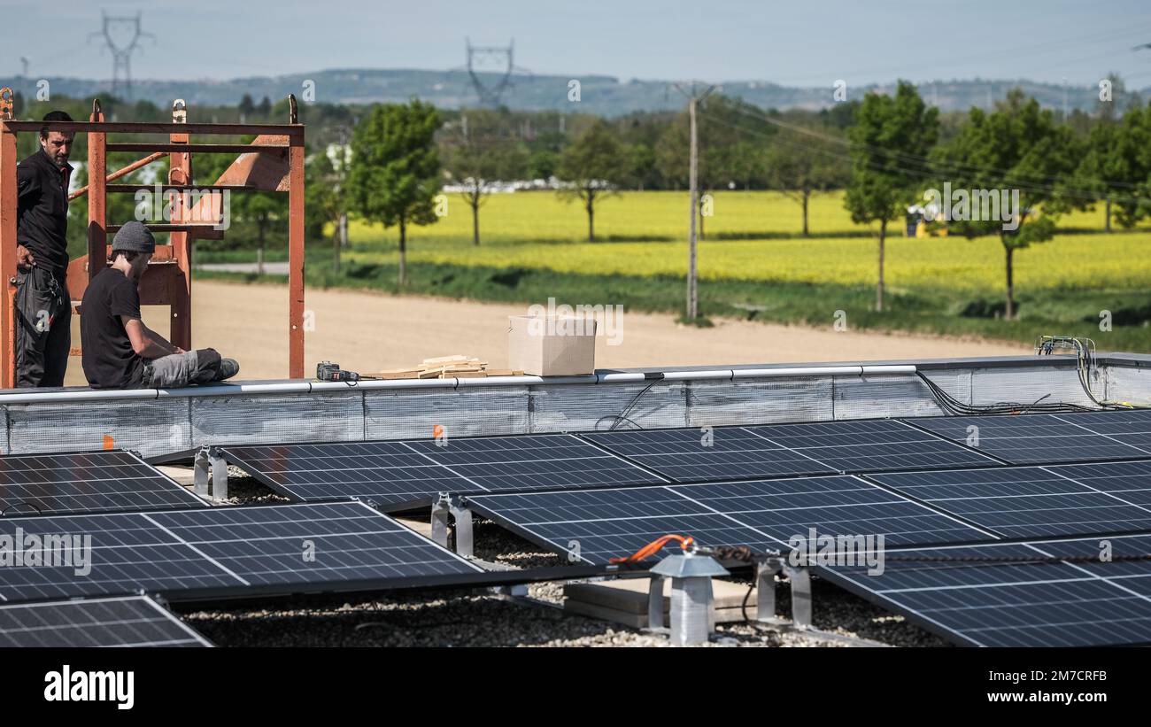 Male team engineers installing stand-alone solar photovoltaic panel ...