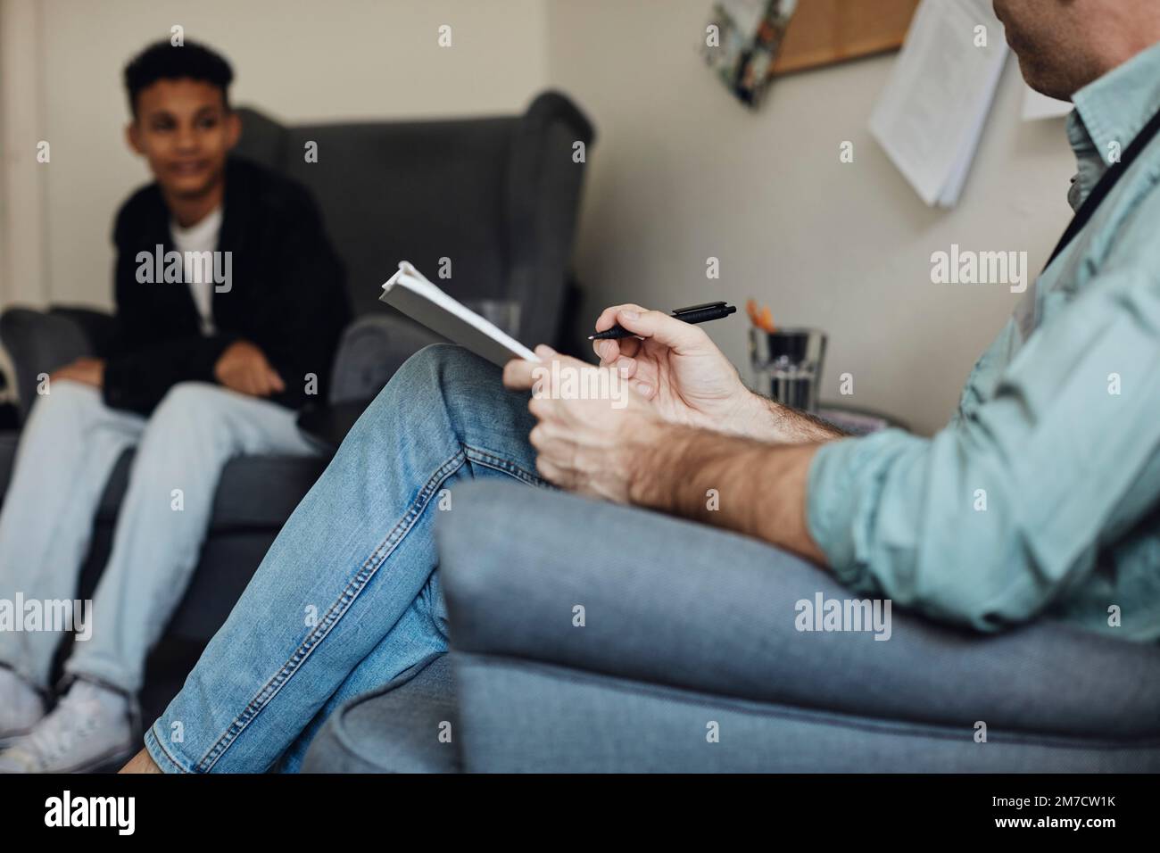 Male counselor discussing with student in school office Stock Photo - Alamy