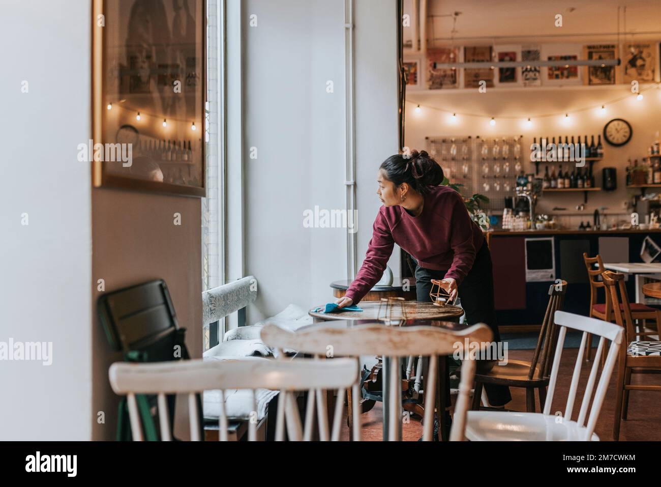 Female entrepreneur cleaning table with rag while working in cafe Stock ...