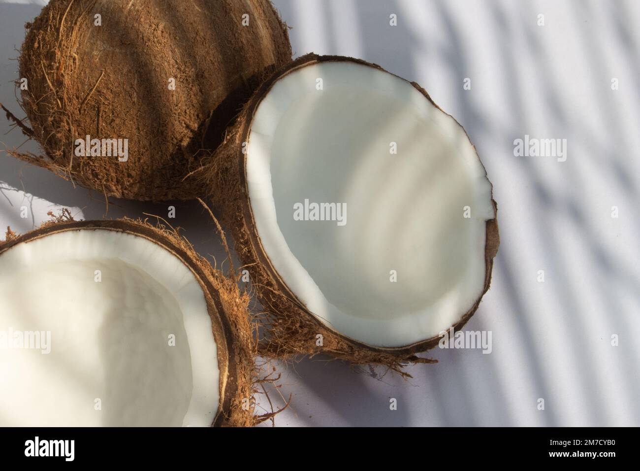 Tropical fruit concept, Halves of fresh coconuts on white fabric ...