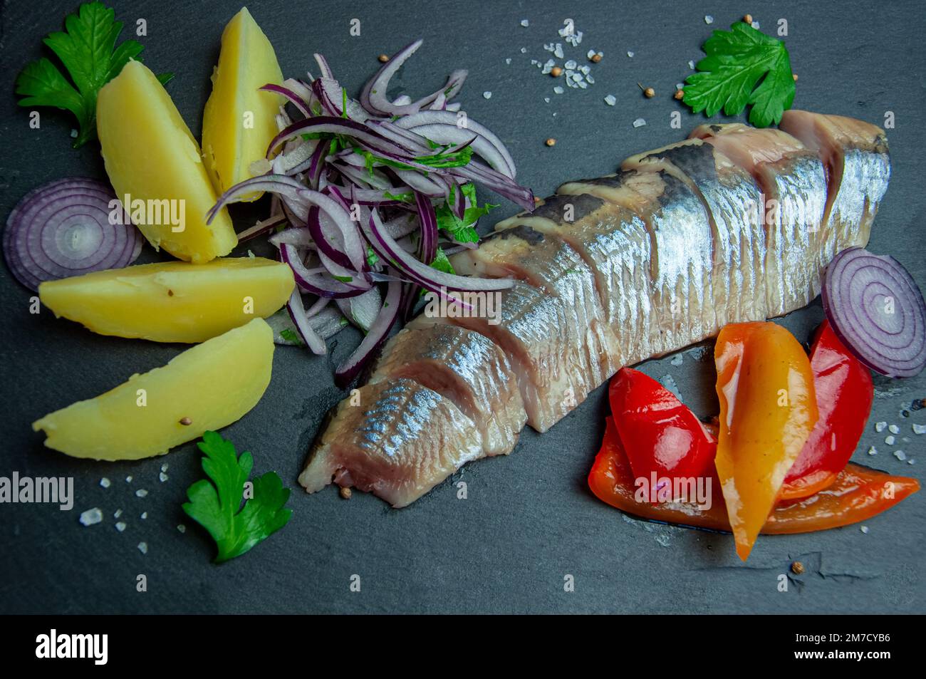 Sliced marinated herring fillet with onions, potatoes, dill and pepper ...