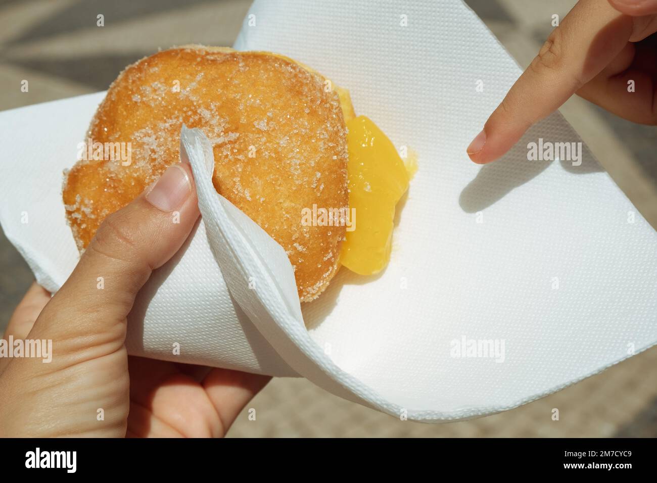 Hand holding Bola de Berlim or Berlim Ball, a Portuguese pastry made ...