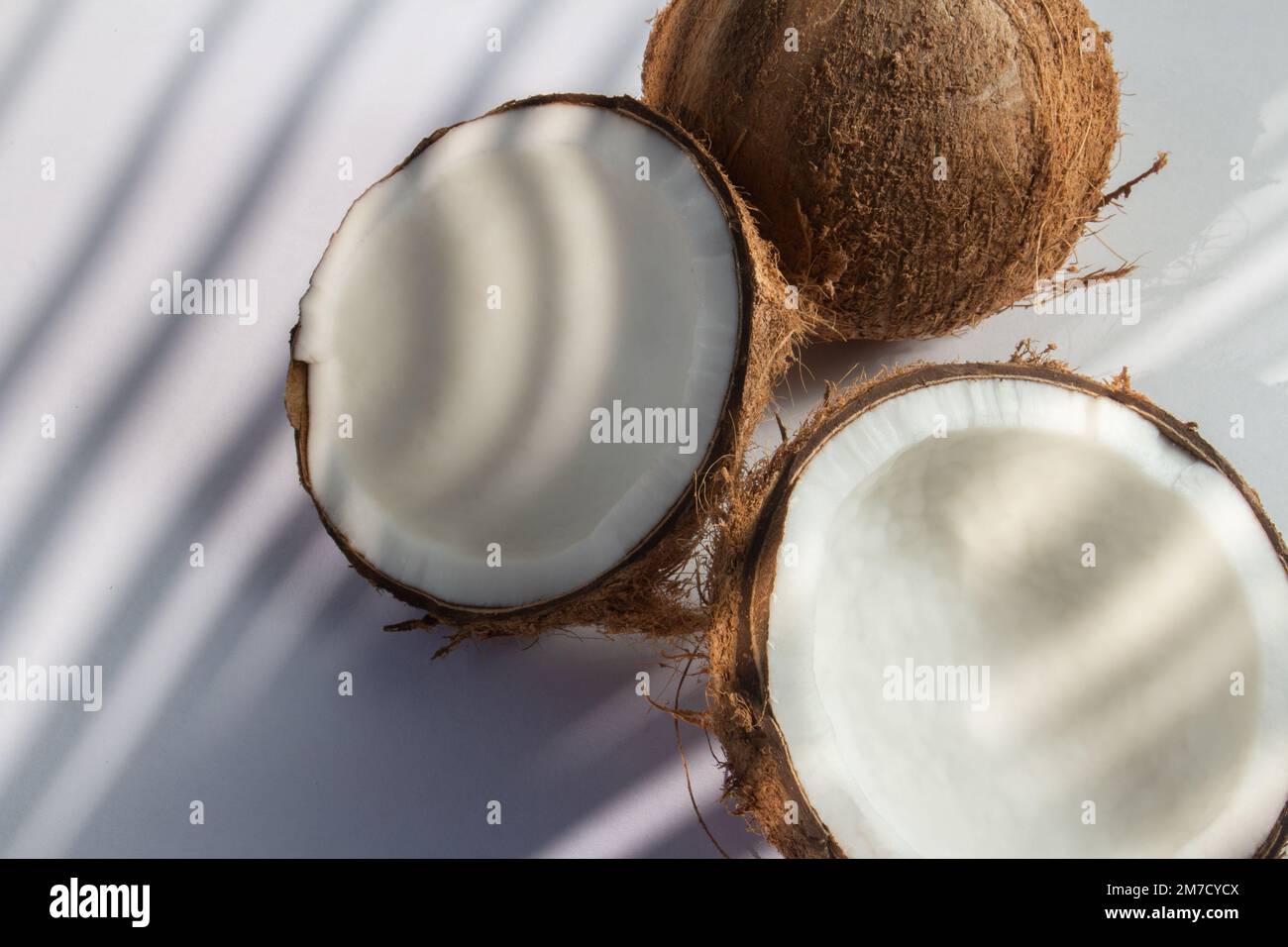 Tropical fruit concept, Halves of fresh coconuts on white fabric ...