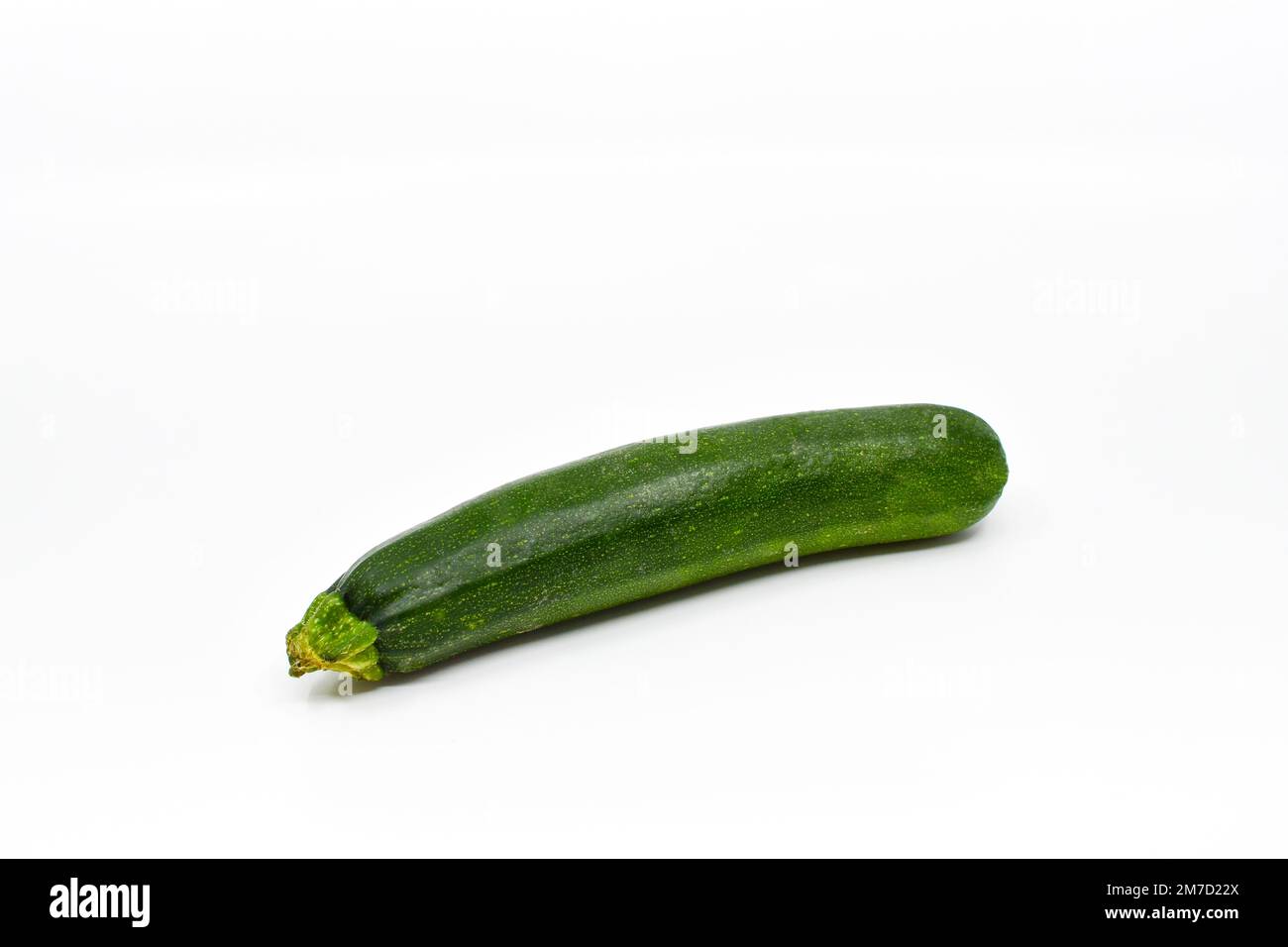Single courgette or zucchini on a plain white background. Copy space ...