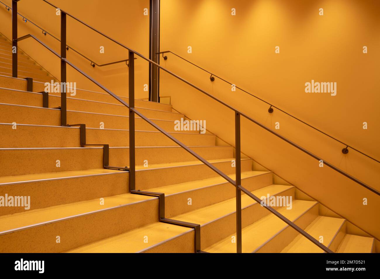 Interior view of modern painted yellow and orange staircase and black ...